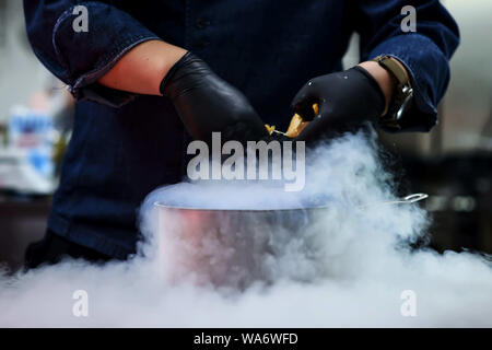 Liquid Nitrogen in a pan. Cooking. Steam. Cook. Against the background ...
