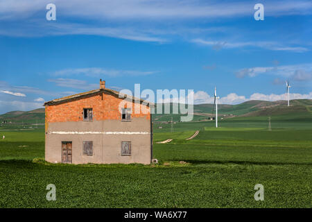 Wind turbines in the country side against a blue sky with clouds ...