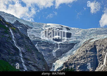 Waterfalls at the glacier tongue Kjenndalsbreen, glacier and mountain ...