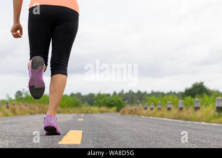 Closeup woman running towards on the road side. Step, run and outdoor ...