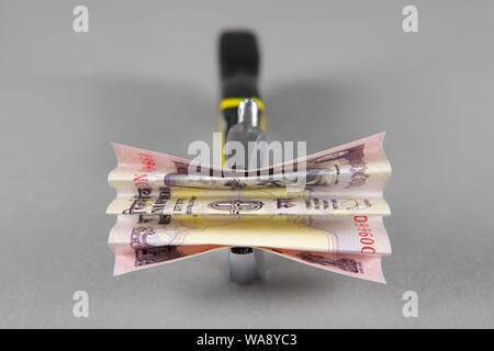 Wrench squeezing Indian fifty rupee banknote Stock Photo - Alamy