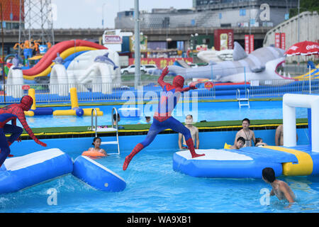 Chinese staff memers dressed as Spider-Man play in a swimming pool ...