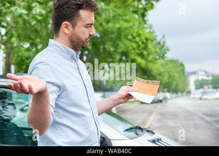 Angry man finds parking ticket after parking time limit expired Stock ...