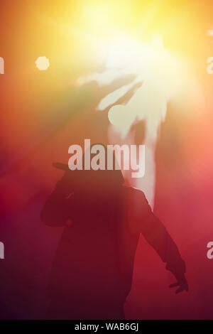 A rapper performing with a red background Stock Photo - Alamy