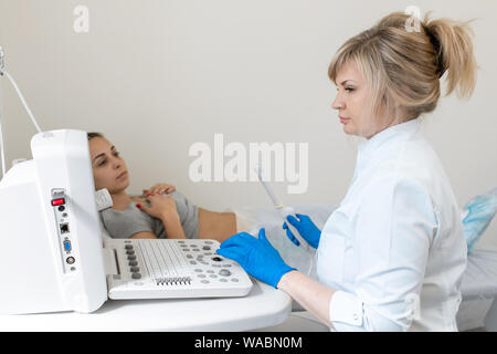A gynecologist sets up an ultrasound machine. A transvaginal ultrasound ...