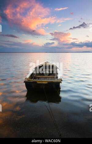 A rowboat overlooking an amazing sunset Stock Photo - Alamy