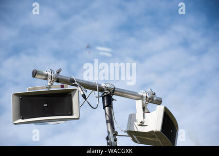 A sound amplifying speaker at airshow with flying display in background ...
