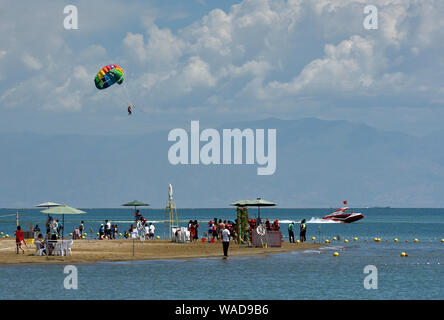 A tourist tries out flying paraglider above the Bosten Lake, one of the ...