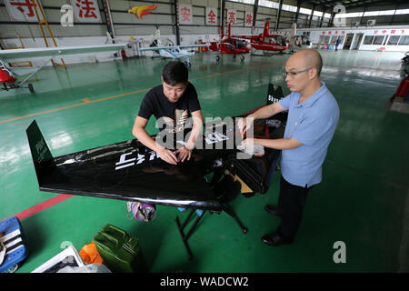 Chinese athlete Sheng Guangqiang checks a jetwing powered by turbojet ...