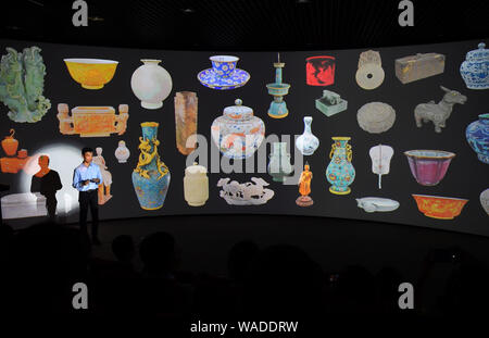 A staff member introduces a new digital product at the Palace Museum ...
