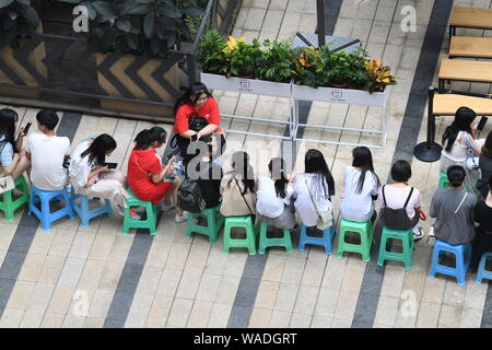 Chinese fans wait in a long queue in front of a milk tea store operated ...