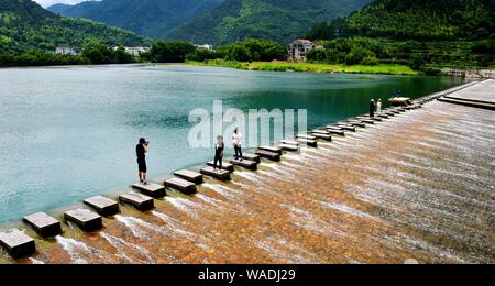 Tourists have fun as they walk on the Shui Ding Bu Path across the ...