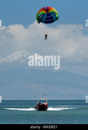 A tourist tries out flying paraglider above the Bosten Lake, one of the ...