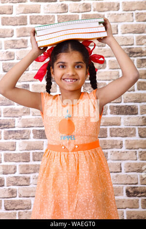 Happy indian school girl pointing advertising isolated on violet ...