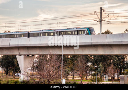 High-speed, driverless metro train travels across a city skyline on a ...