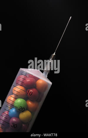 Close up of a syringe filled with candy on a black background Stock ...