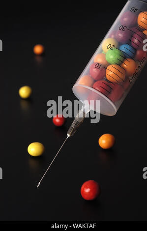 Injection with needle filled with sugar on black rustic background ...