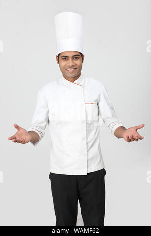 Chef smiling with his arm outstretched Stock Photo - Alamy