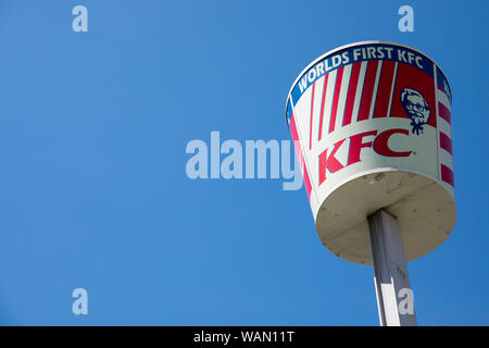 A logo sign outside of the first Kentucky Fried Chicken (KFC) franchise ...