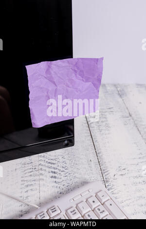 Notation paper taped to black computer monitor screen near white ...