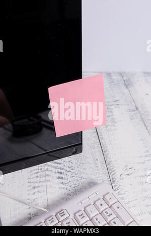 Notation paper taped to black computer monitor screen near white ...