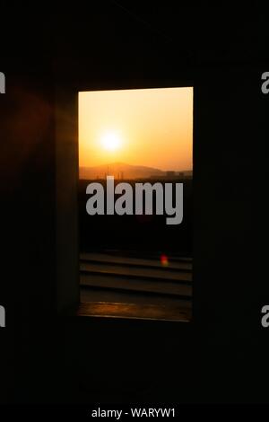 Shot of a sunset through a large glass building facade and ...
