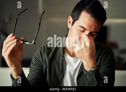 A Caucasian man feeling sick while holding a medicine and lying on the ...