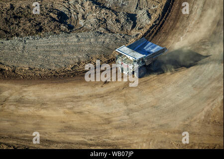 Giant trucks haul bitumen rich ore from mining operations to oil sands ...