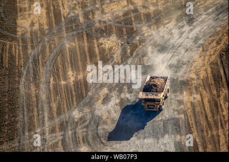 Giant trucks haul bitumen rich ore from mining operations to oil sands ...