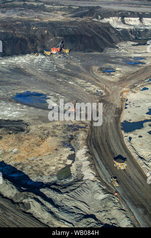 Giant trucks haul bitumen rich ore from mining operations to oil sands ...