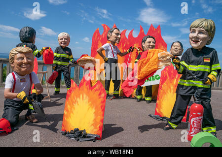 Firefighters stand in front of a row of damaged brownstone buildings ...