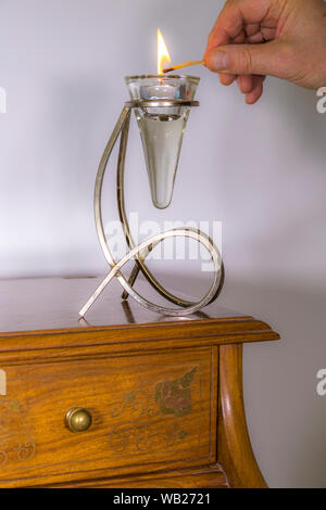 Closeup shot of a candle with a wooden wick burning with a blurred ...