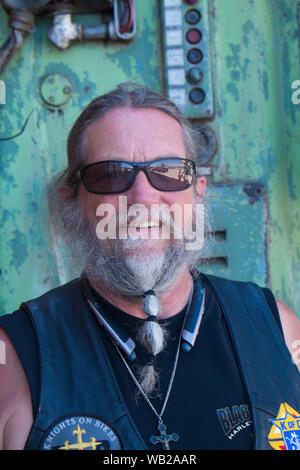 smiling bearded man in sunglasses talking on smartphone near plane ...