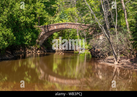 Stone Arch Footbridge Over A Creek Stock Photo - Alamy
