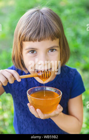 Child a plate of honey in the hands. Selective focus Stock Photo - Alamy