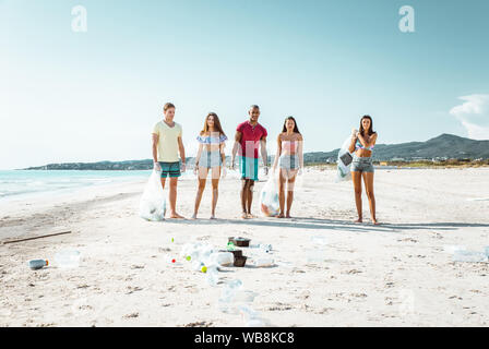 Group of activists friends collecting plastic waste on the beach ...