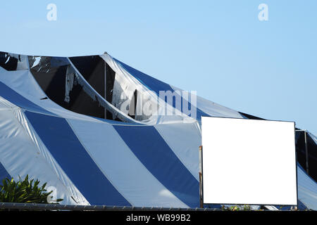 Ragged tent. Big hole. Striped blue-white fabric Stock Photo - Alamy