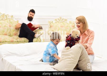 Mother is indifferent to her little son, mom looks at the smartphone ...