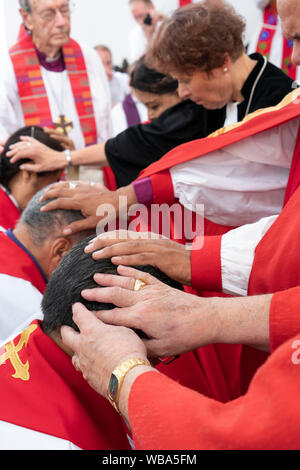 Traditional laying on of hands blessing during ordination ceremony for ...