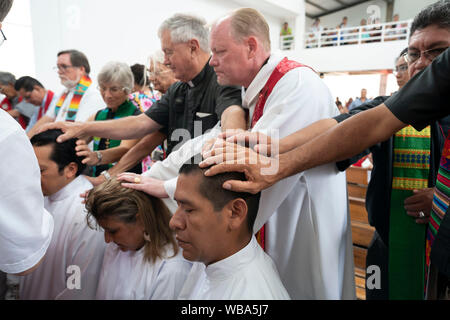 Traditional laying on of hands blessing during ordination ceremony for ...