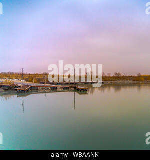 Gleaming lake with reflections of lush grasses and cloudy sky on its ...
