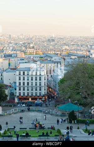 Tourist crowds enjoying evening sunset view over Paris from hill and ...