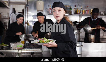 Confident female chef with a team of cooks in restaurant kitchen Stock ...