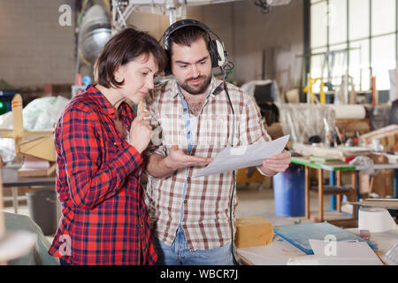 Team of aircraft enthusiasts working in workshop on creating of ...