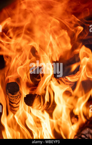 Flames of fire in charcoal with firewood Stock Photo - Alamy