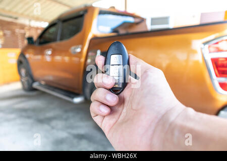 A man opening his car door with pushing button on control remote key ...