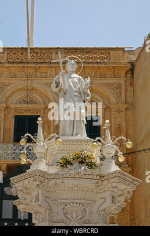 St. Lawrence statue; 16 century; large pedestal; flowers, lights ...