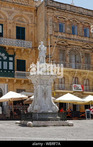 St. Lawrence statue; 16 century; stone, ornate pedestal; flowers ...