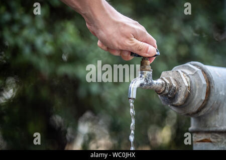 Man hand opening tap with water in bidet. Contemporary ceramic ...