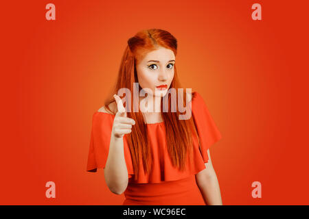 Woman directing at camera with index finger and smiling friendly as if ...